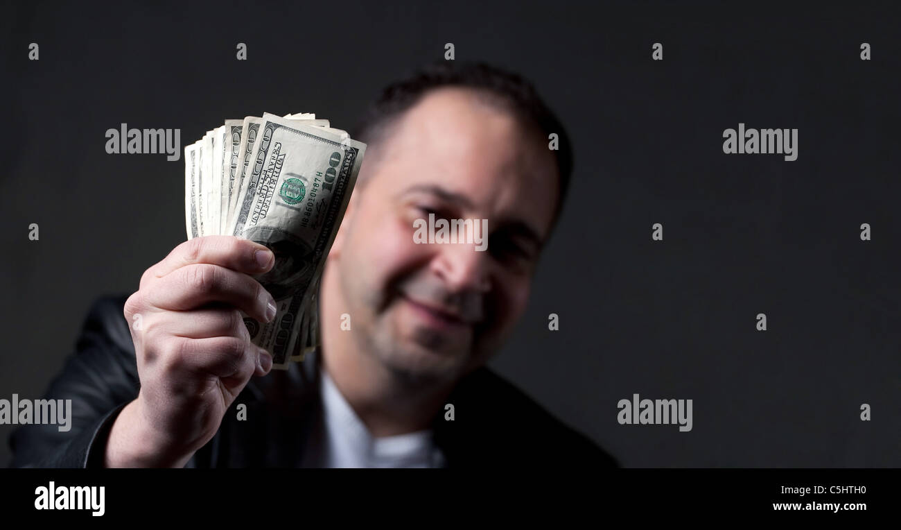 A happy middle aged man holding a handful of money with copyspace Stock ...