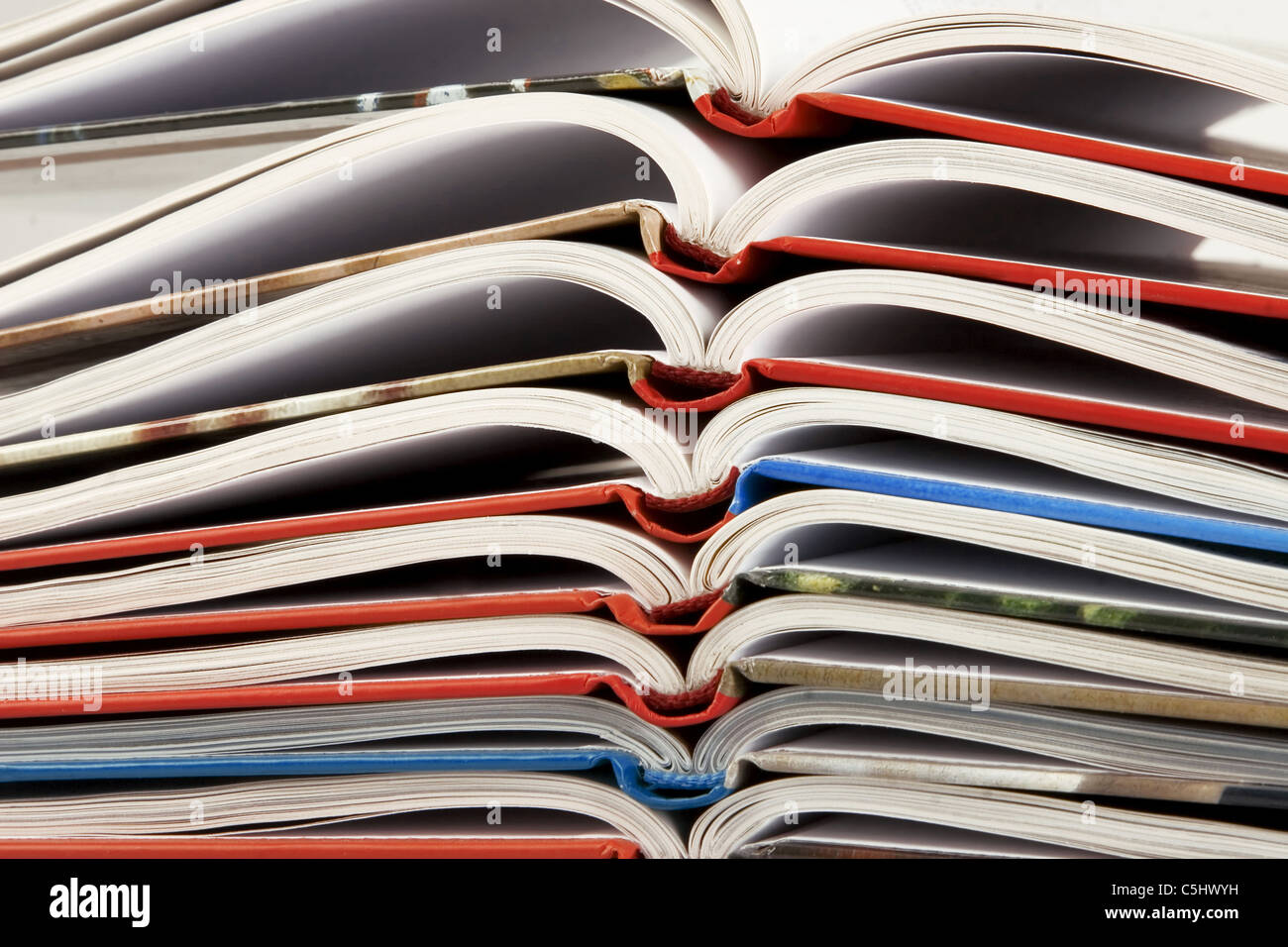 pile of new book with bending pages on white background Stock Photo - Alamy