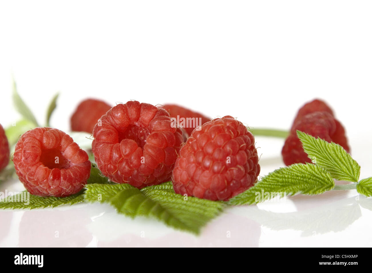 Ripe raspberry with green leaf on white background Stock Photo - Alamy