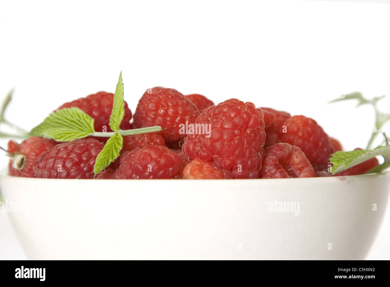 Ripe raspberry with green leaf on white background Stock Photo - Alamy