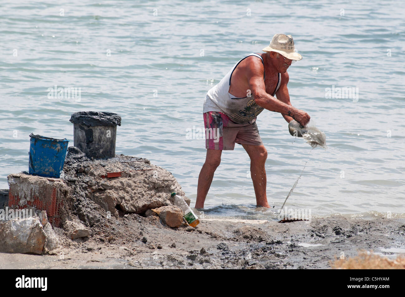 Local man digs out therapeutic mud on the seashore at Lo Pagan, Region ...
