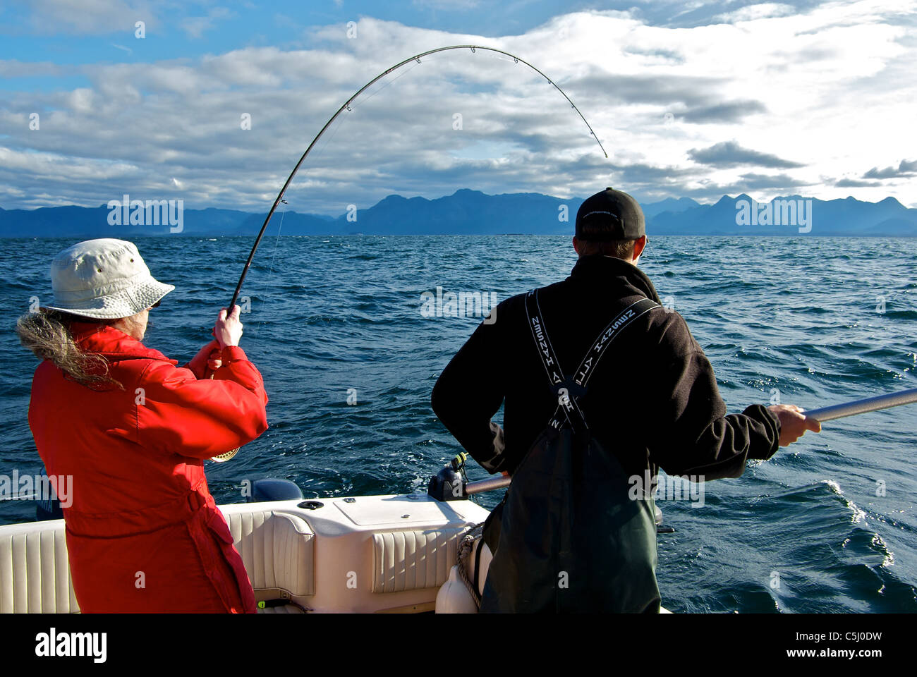 sport fishing guide ready to net big Chinook salmon for female angler ...