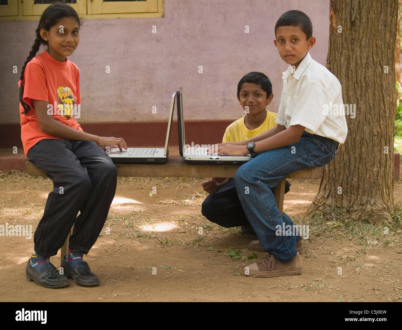 Elementary school students using computers at the village school run ...
