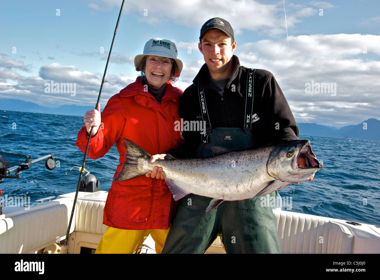 Female angler sport fishing guide holding big Chinook salmon open ...