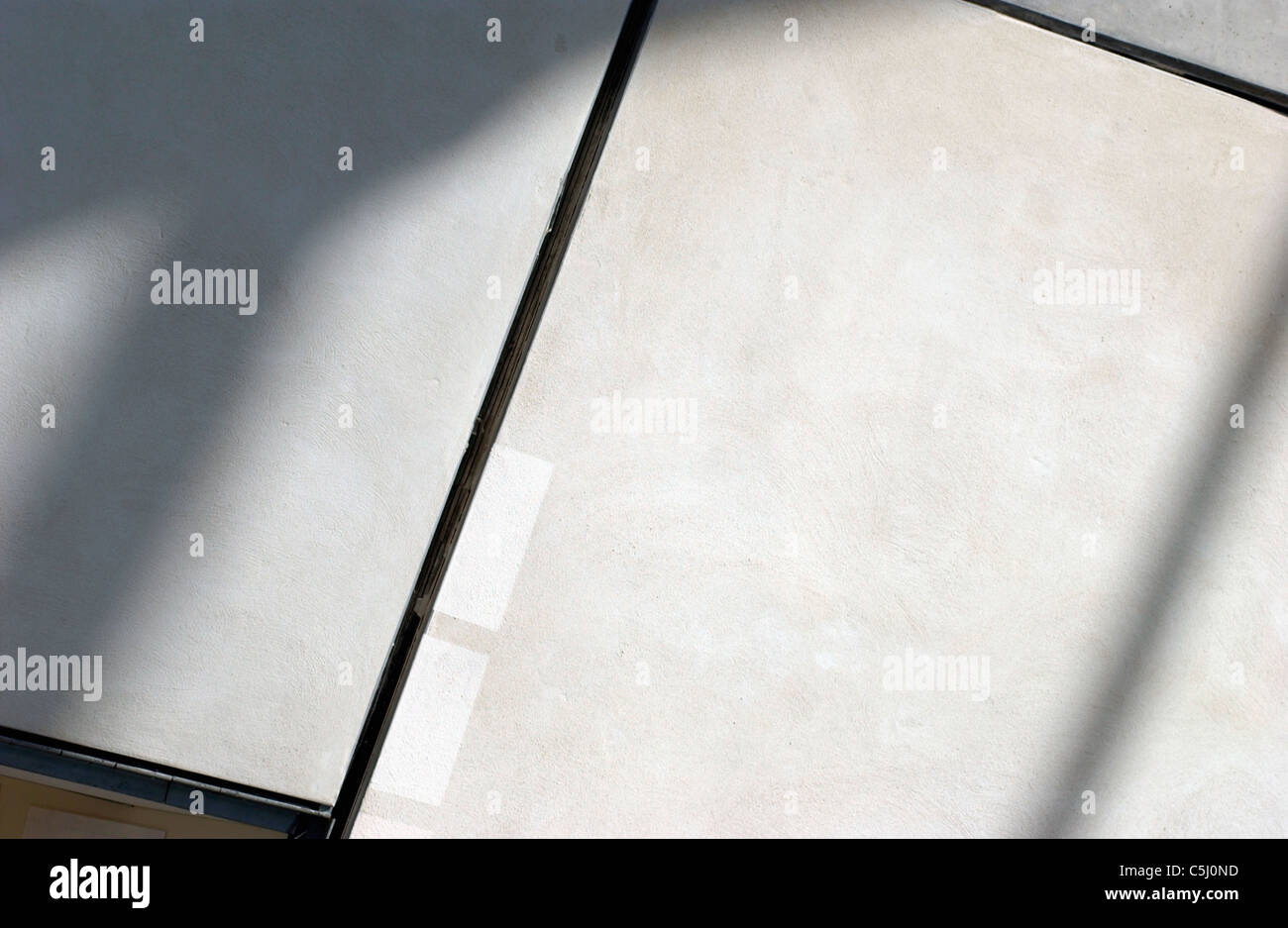 Concrete panels making up a wall with light cast across Stock Photo - Alamy