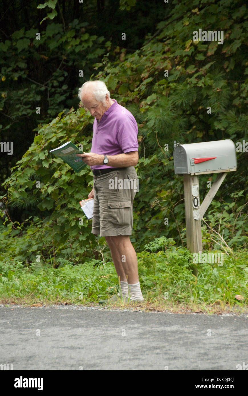 older man looking at his mail from across the road Stock Photo - Alamy