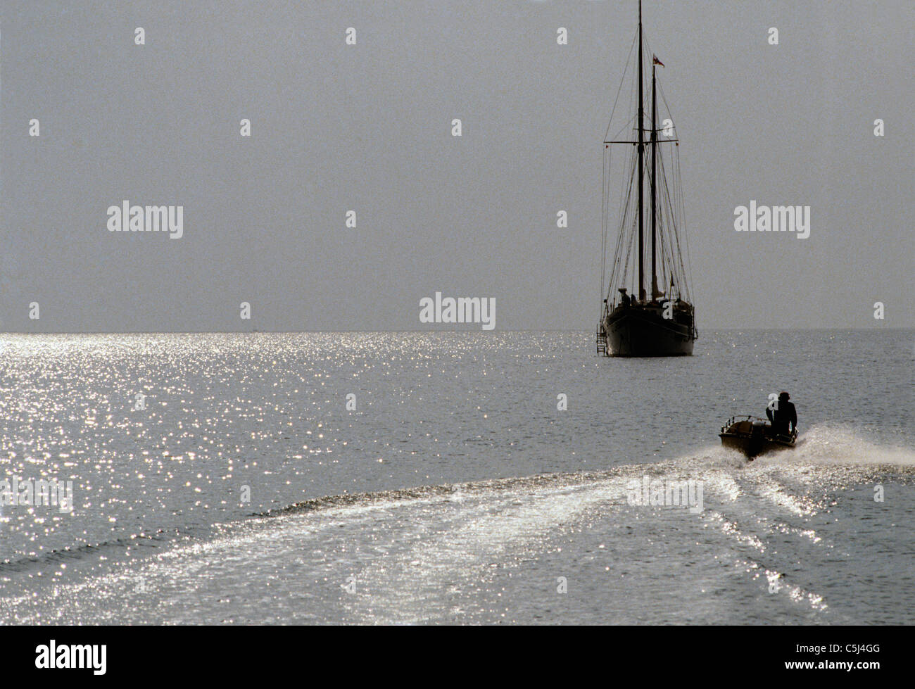 Zodiac speedboat and traditional Mediterranean sailing boat outlined ...