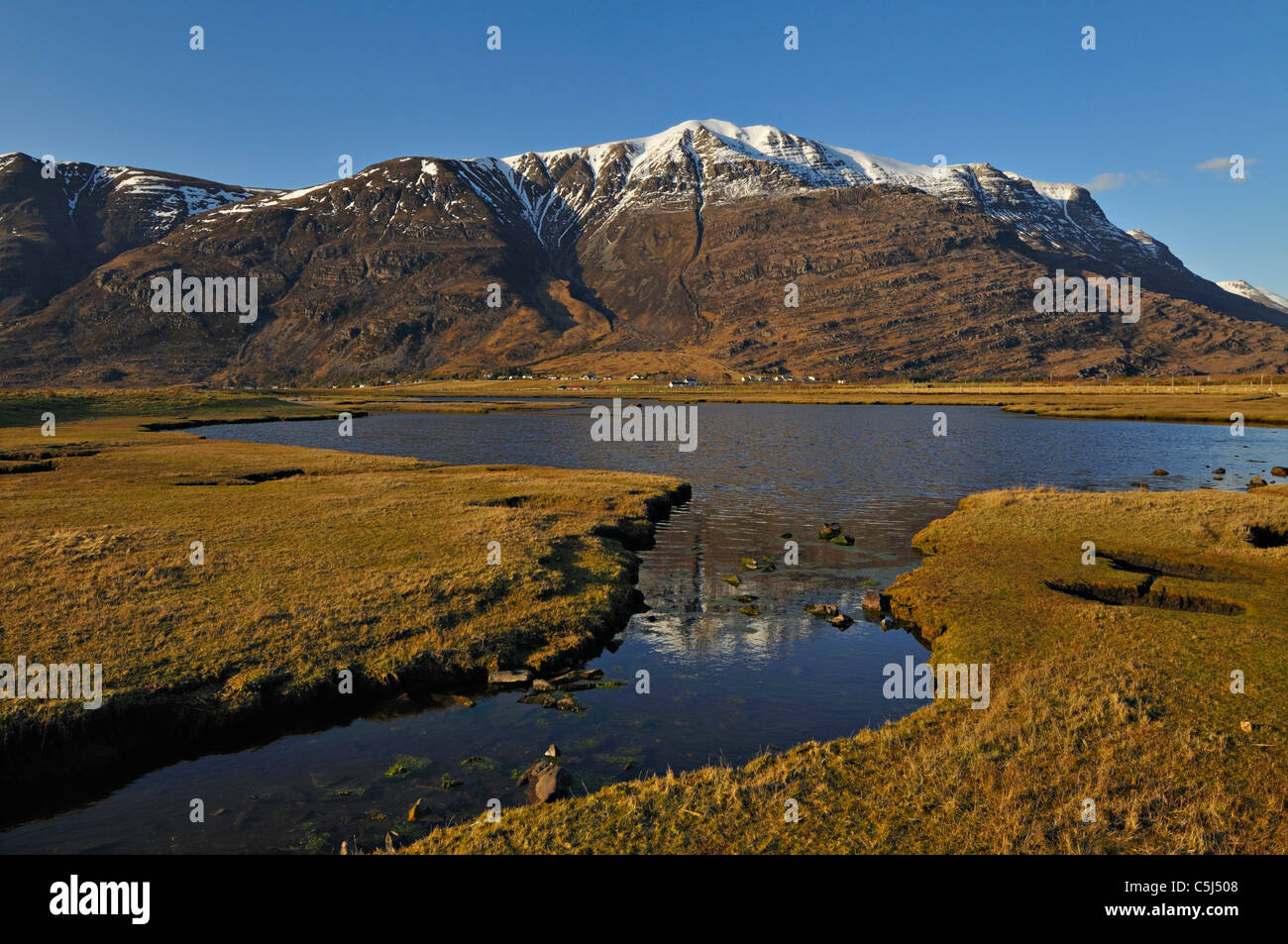 The distant snow-capped peak of Liathach rises above a nearby tidal ...