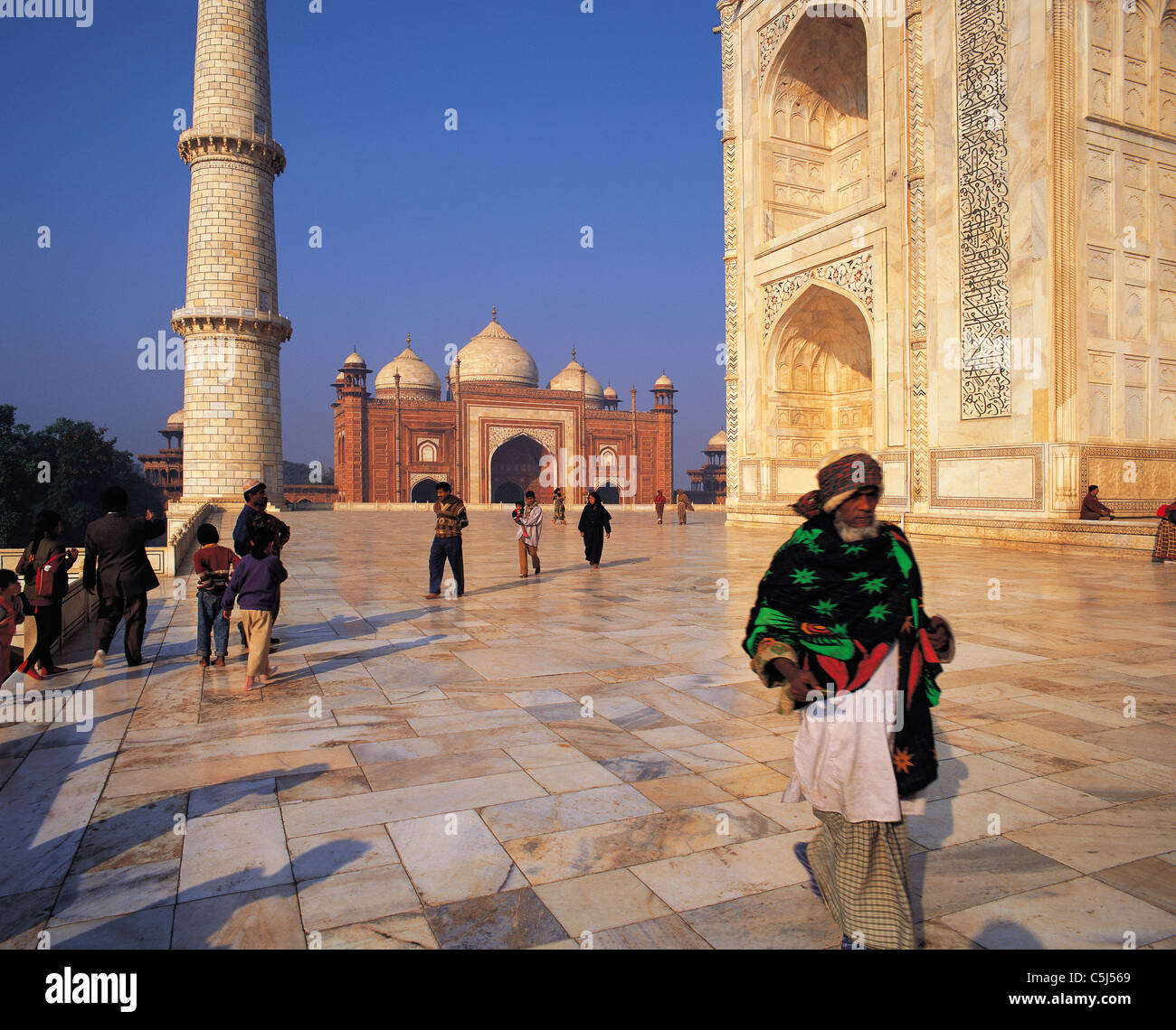 Vistors stroll the upper tiled marble walkway around the Taj Mahal ...