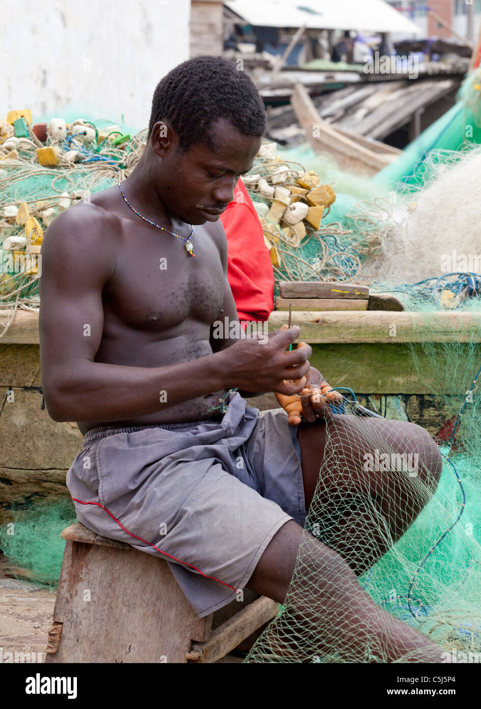 African fisherman repairing fishing net, Cape Coast, Ghana Stock Photo ...