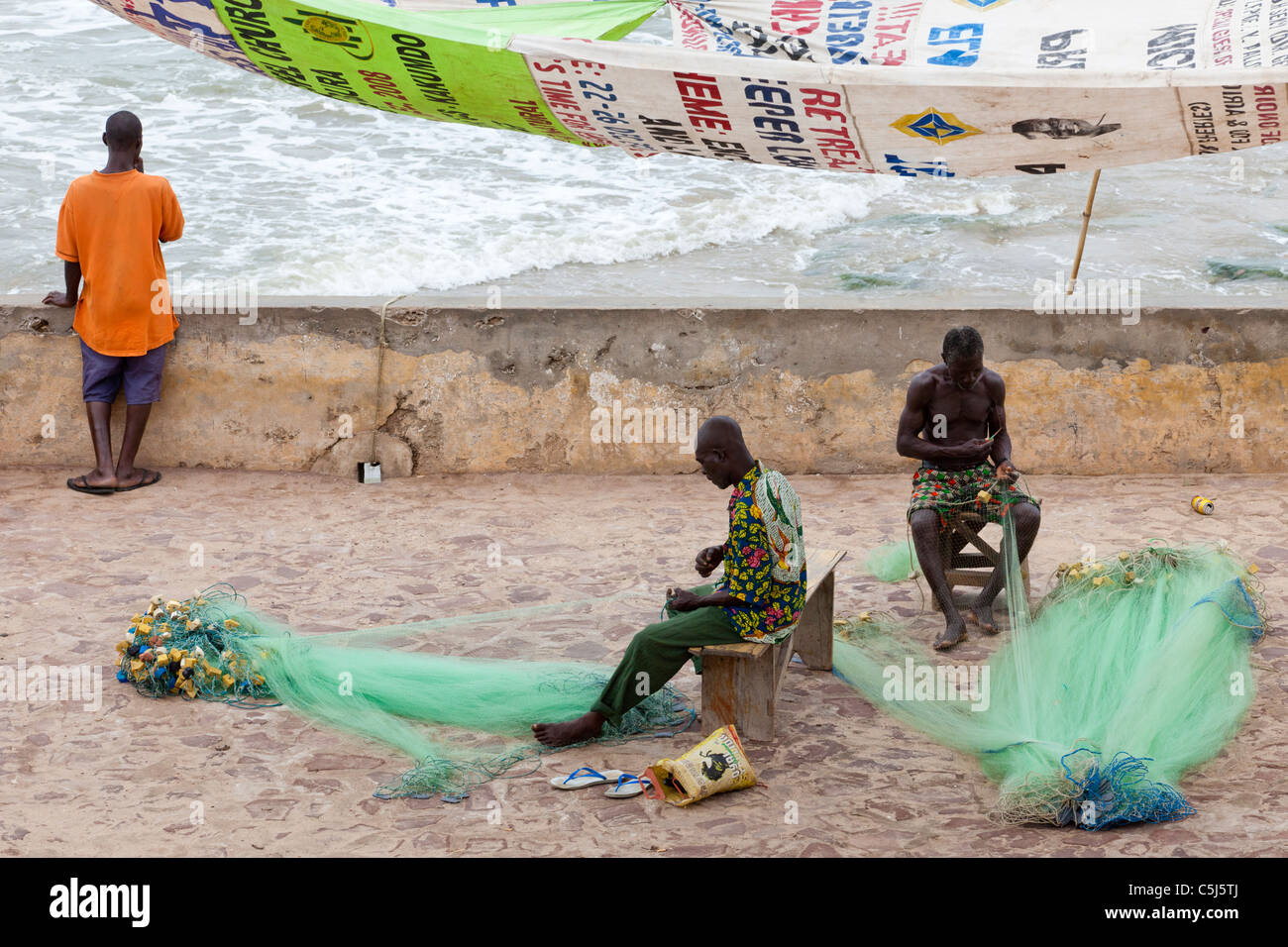 Two African fishermen repairing fishing nets, Cape Coast, Ghana Stock ...