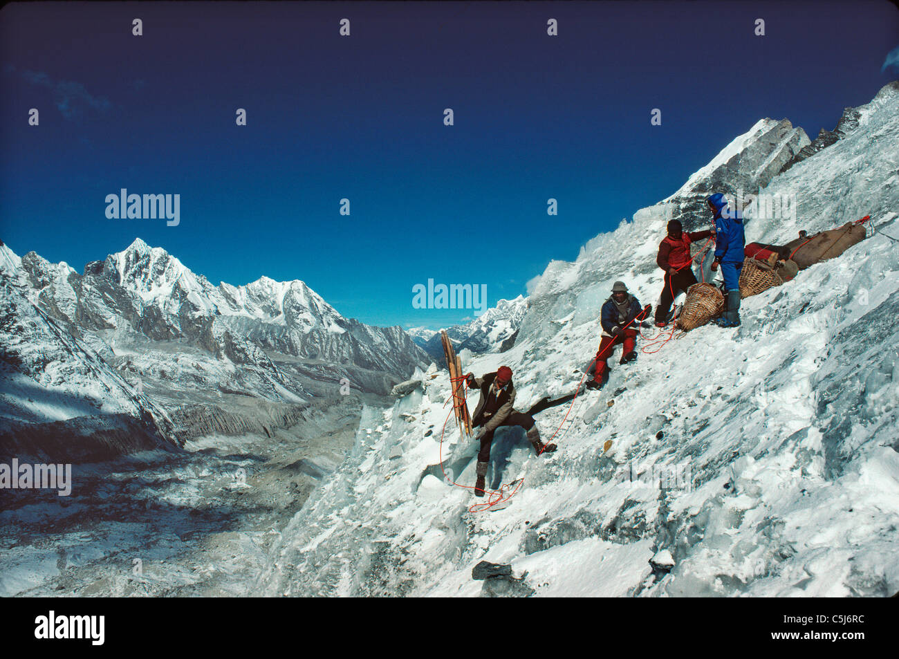 Sherpas haul loads including firewood up steep icy slopes at the start ...
