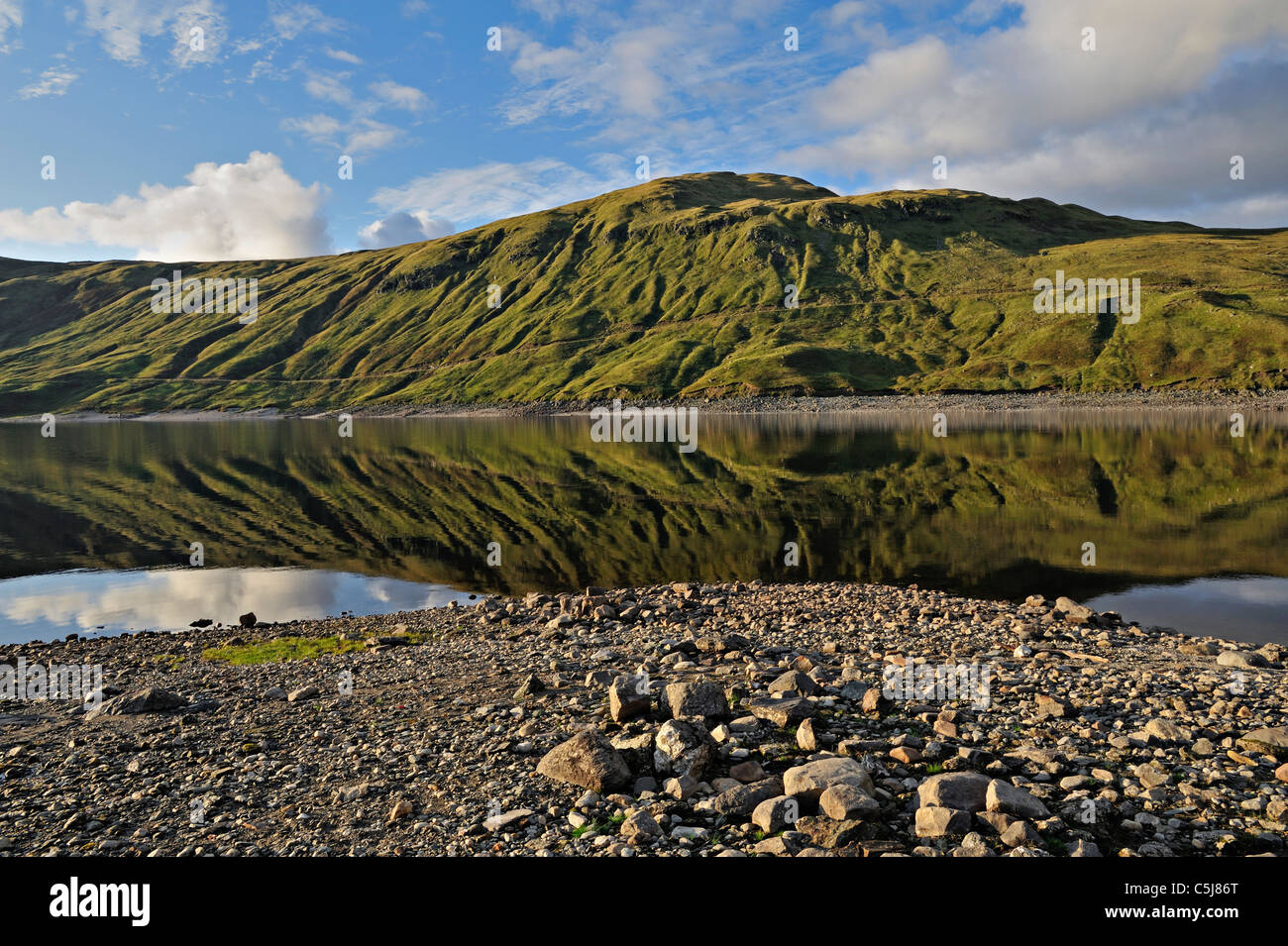 Still water in Loch Lyon reflects the gullied slopes of Craig a ...