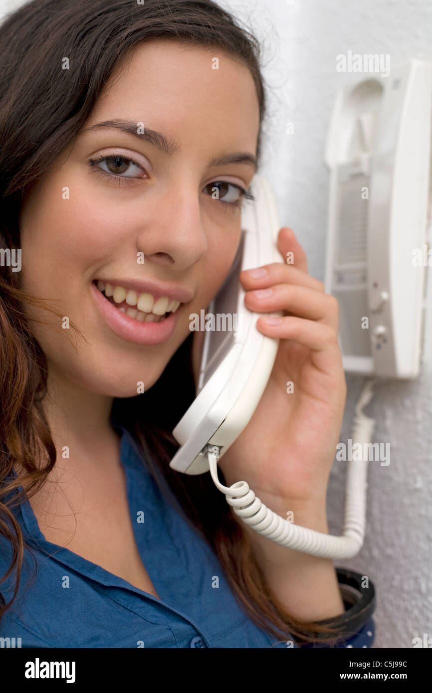 young woman using intercom system Stock Photo - Alamy