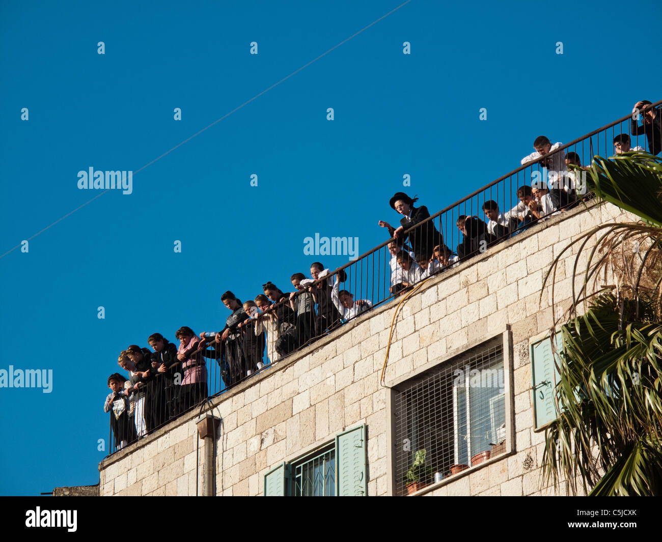 Young Haredi children watch their elders riot below from a rooftop ...