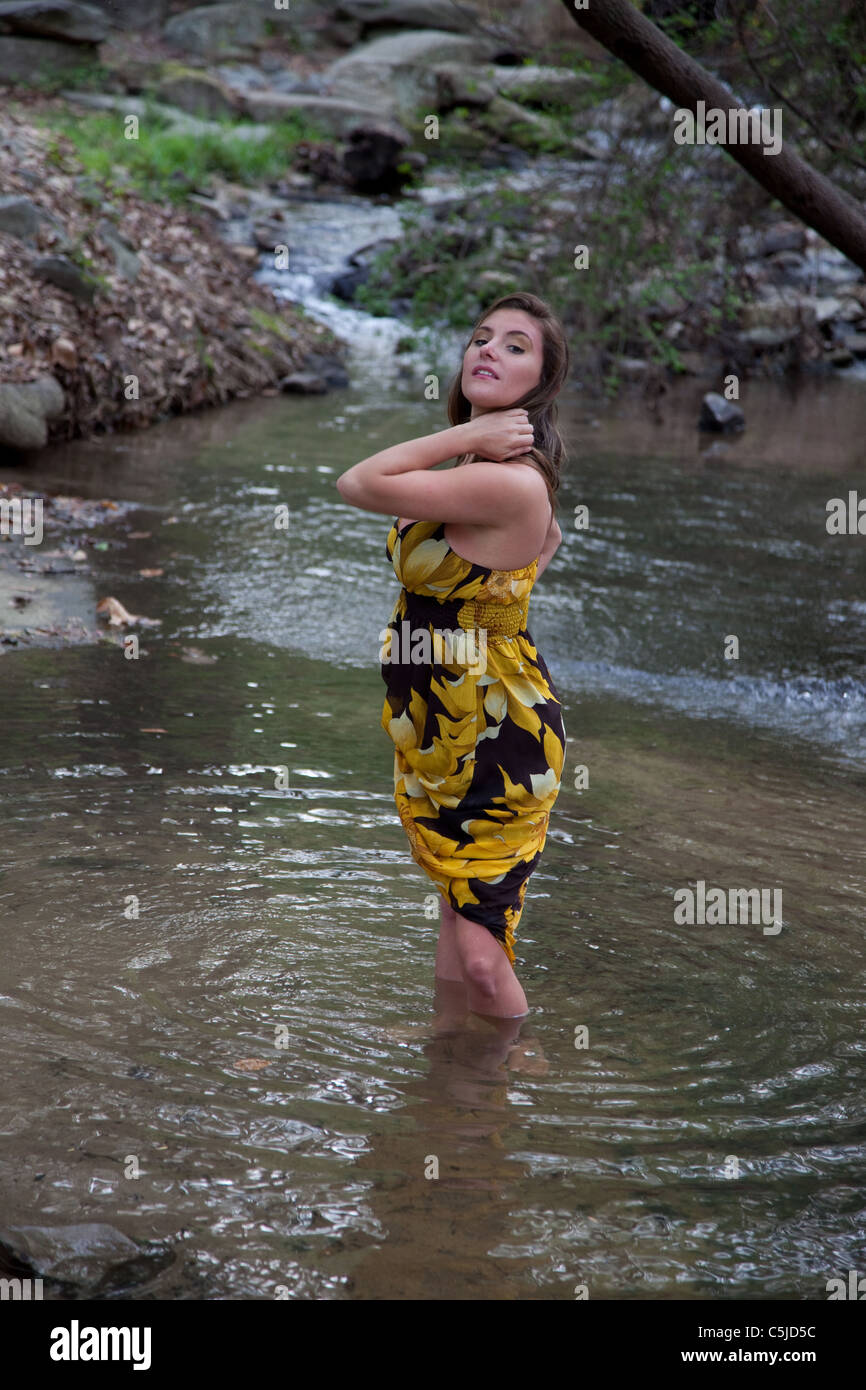 Lovely woman wading in a creek and looking at the camera Stock Photo ...