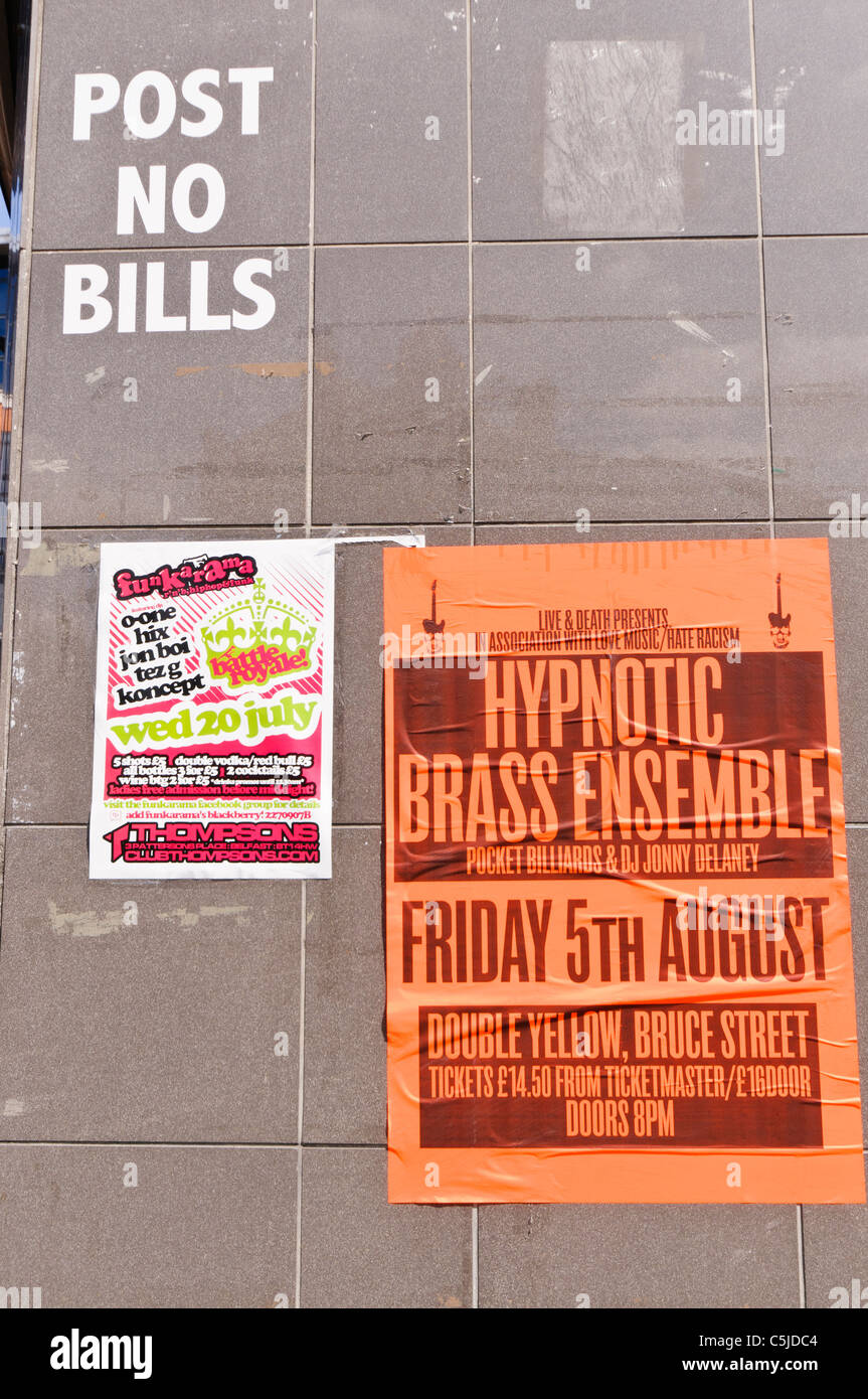 Unsightly fly posters on the wall of a building with a notice saying ...