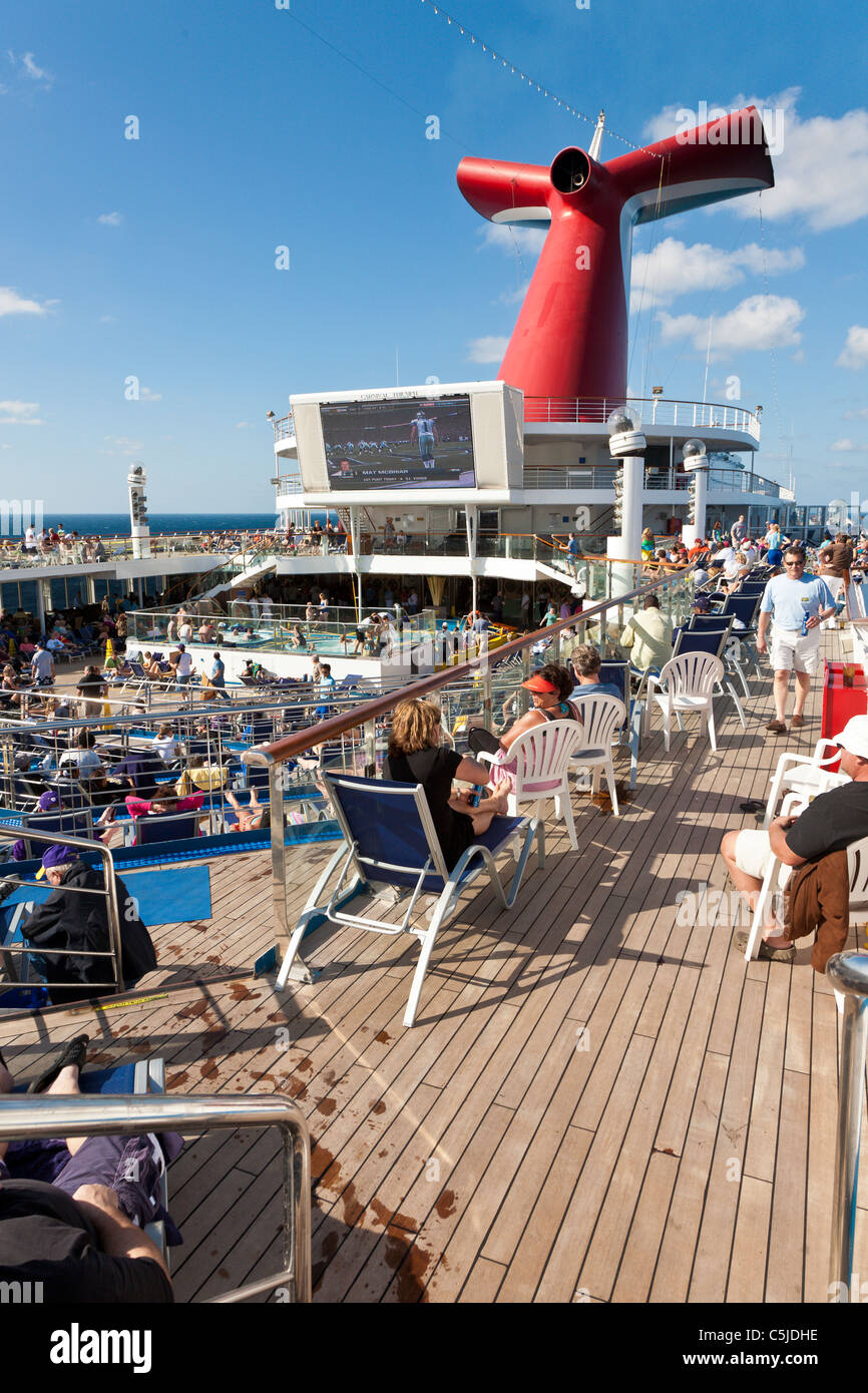 Cruise passengers watching NFL football game on deck of Carnival's ...