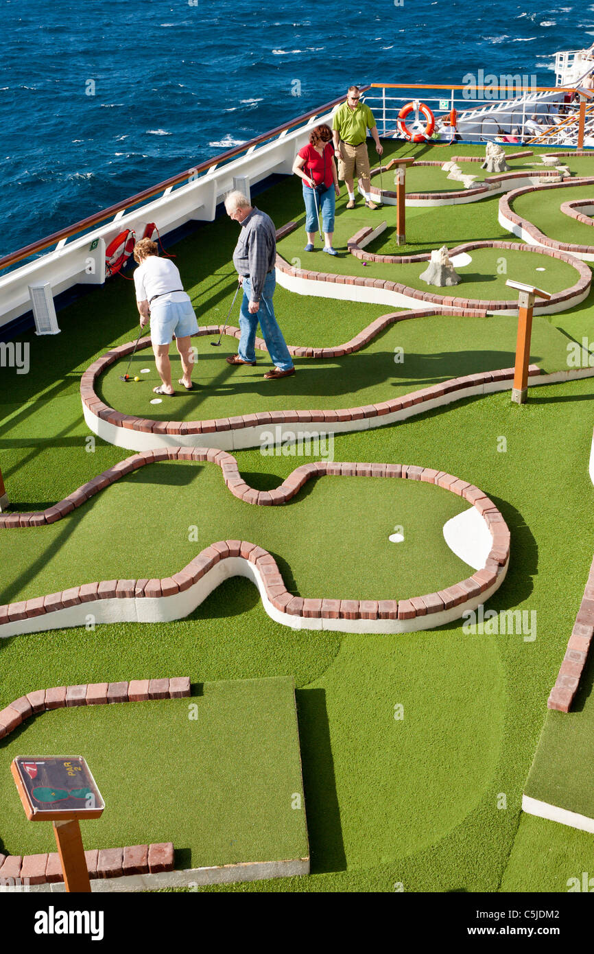Cruise passengers playing miniature golf on the deck of Carnival's ...