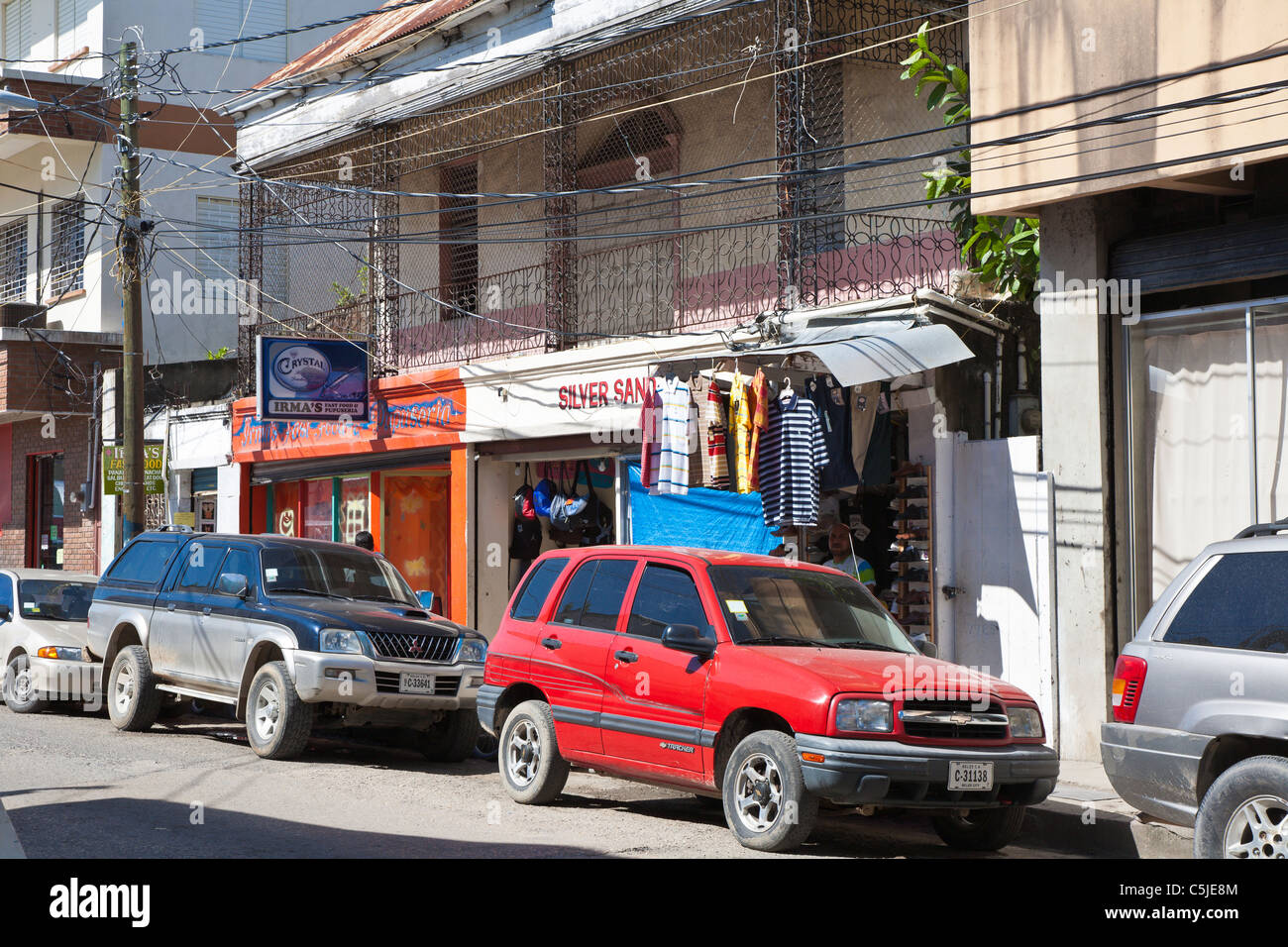 Tangle of electrical wires outside shops on busy street in Belize City ...