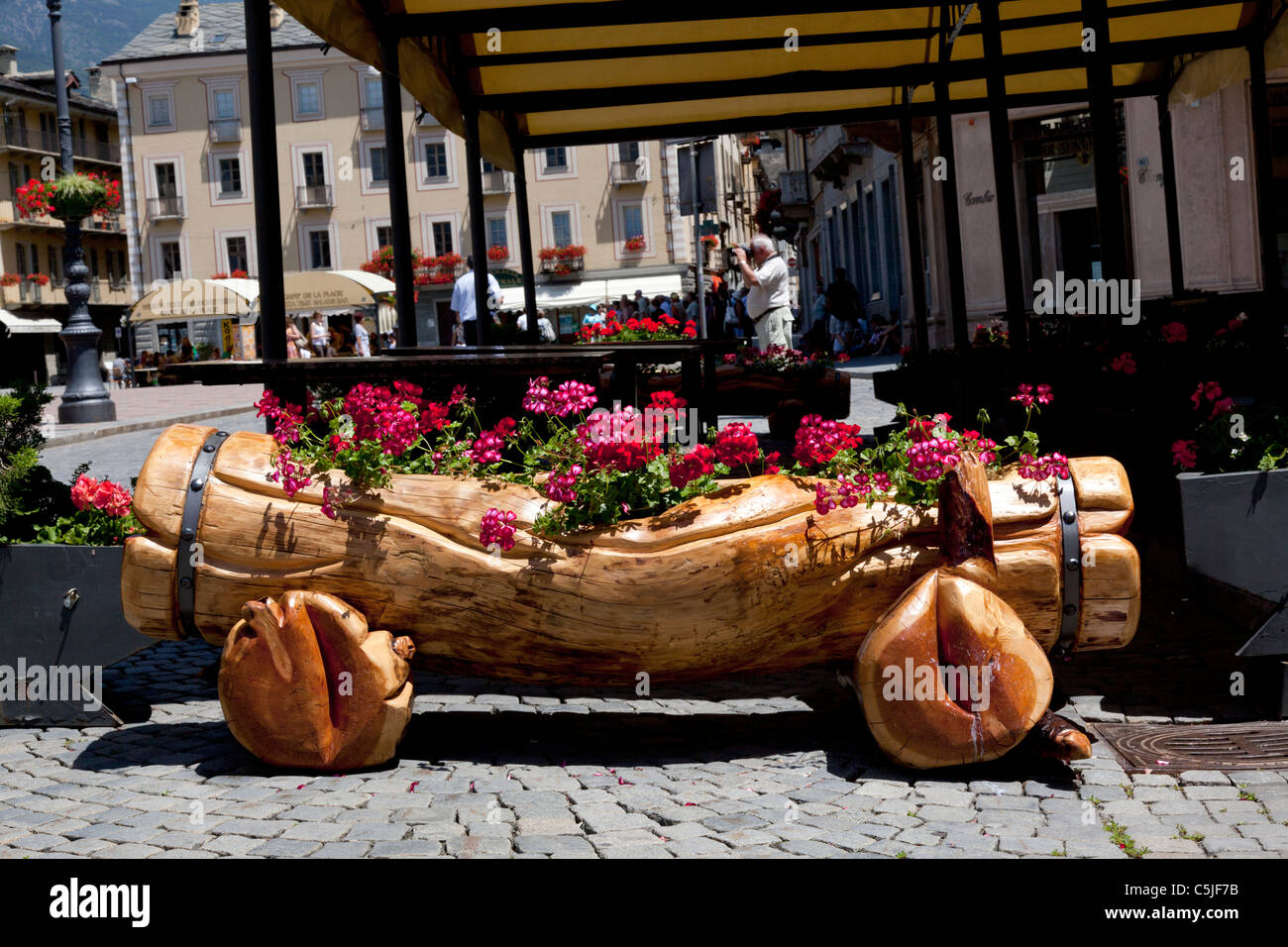 A picturesque planter filled with bright red geraniums (Aosta - Italy ...