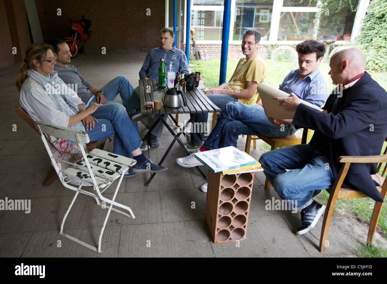 Group of Artists talking at the table Stock Photo - Alamy