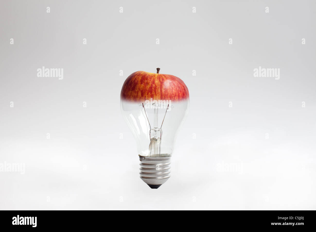 Red apple forming top part of light bulb or globe, isolated on white ...