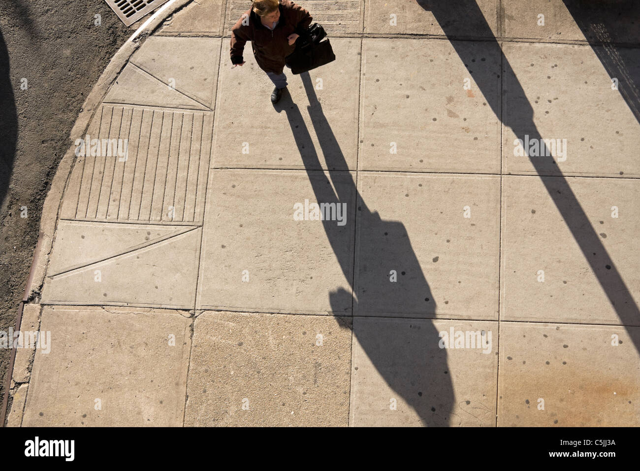 A woman in New York City casts a long shadow in the late afternoon ...