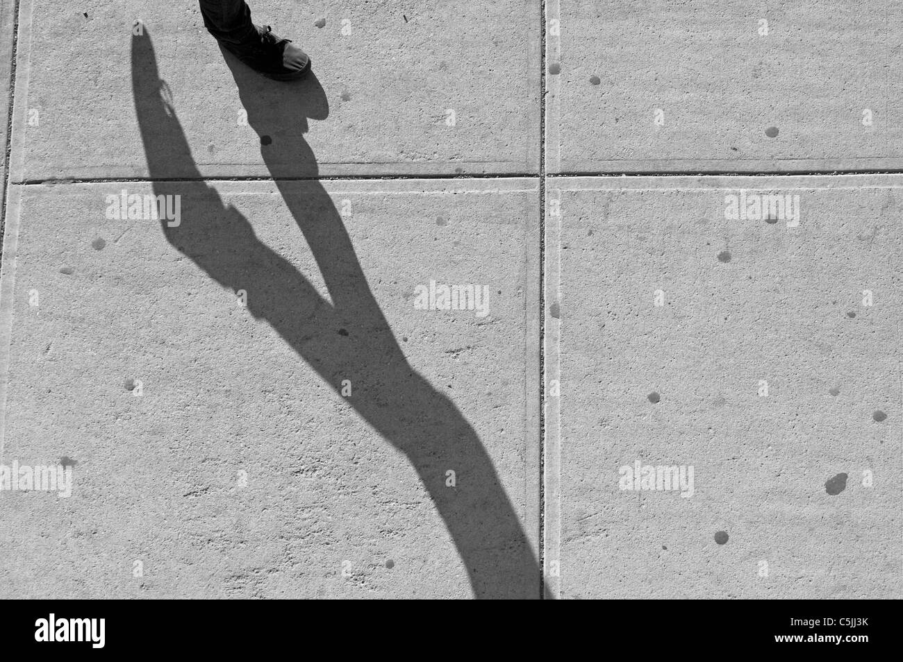 A solitary walker in New York City casts a long shadow Stock Photo - Alamy