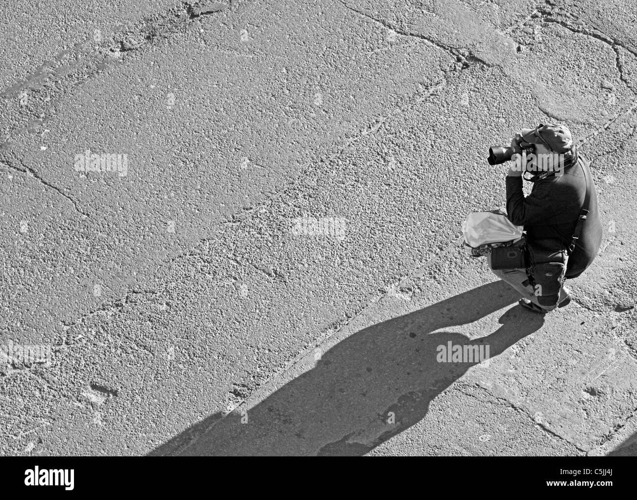 A photographer in New York City casts a long afternoon shadow Stock ...