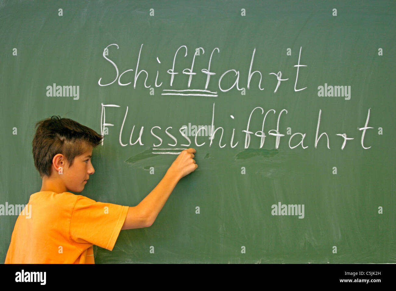 a boy has written German words with new spelling on the board at school ...