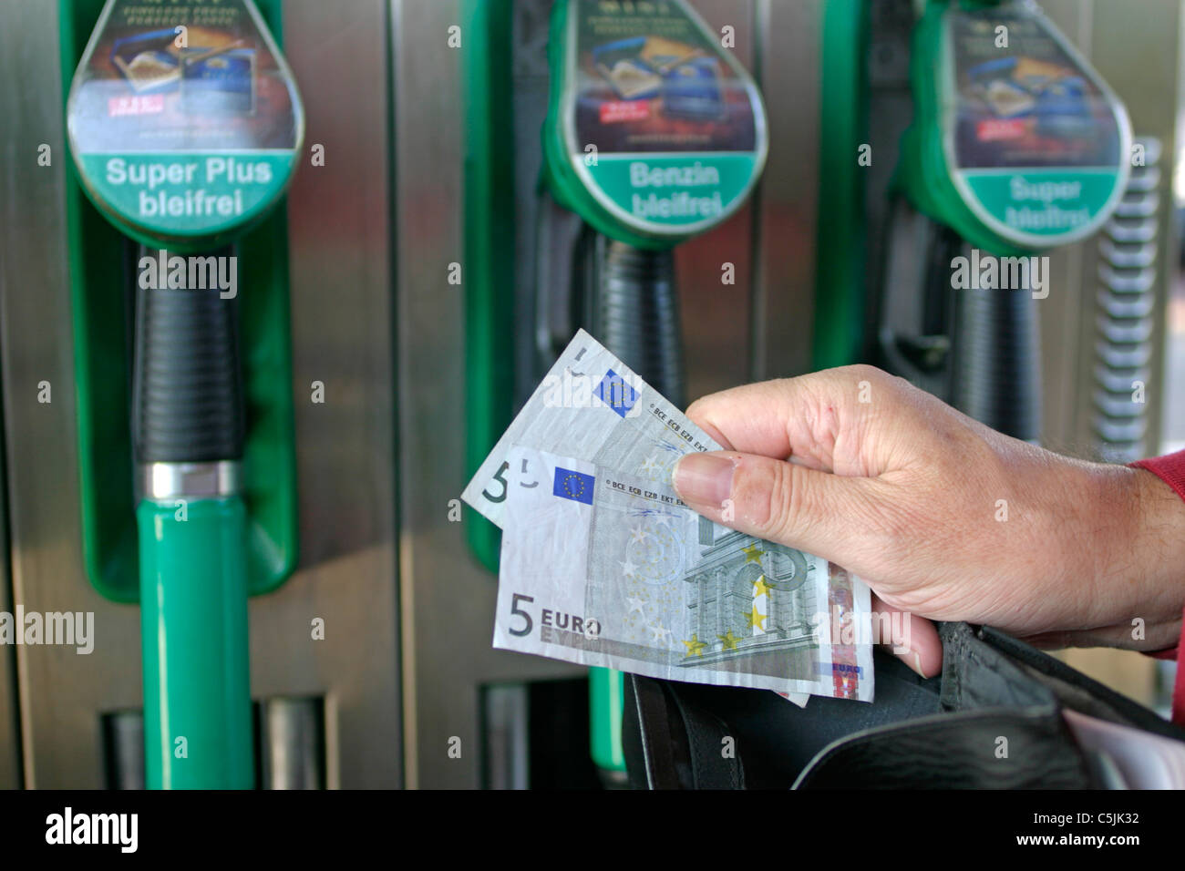 a man counting his money at a petrol station Stock Photo - Alamy