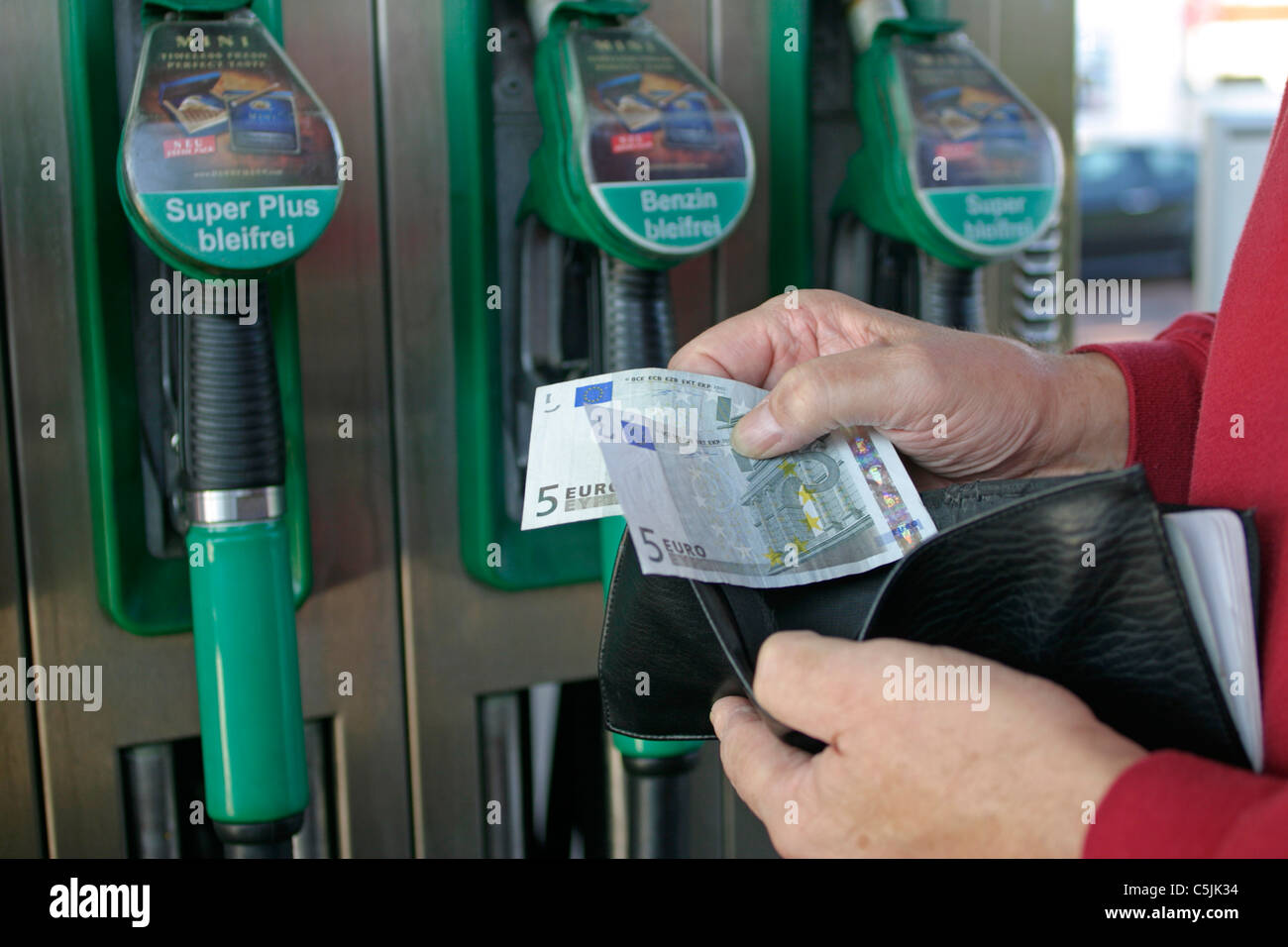 a man counting his money at a petrol station Stock Photo - Alamy