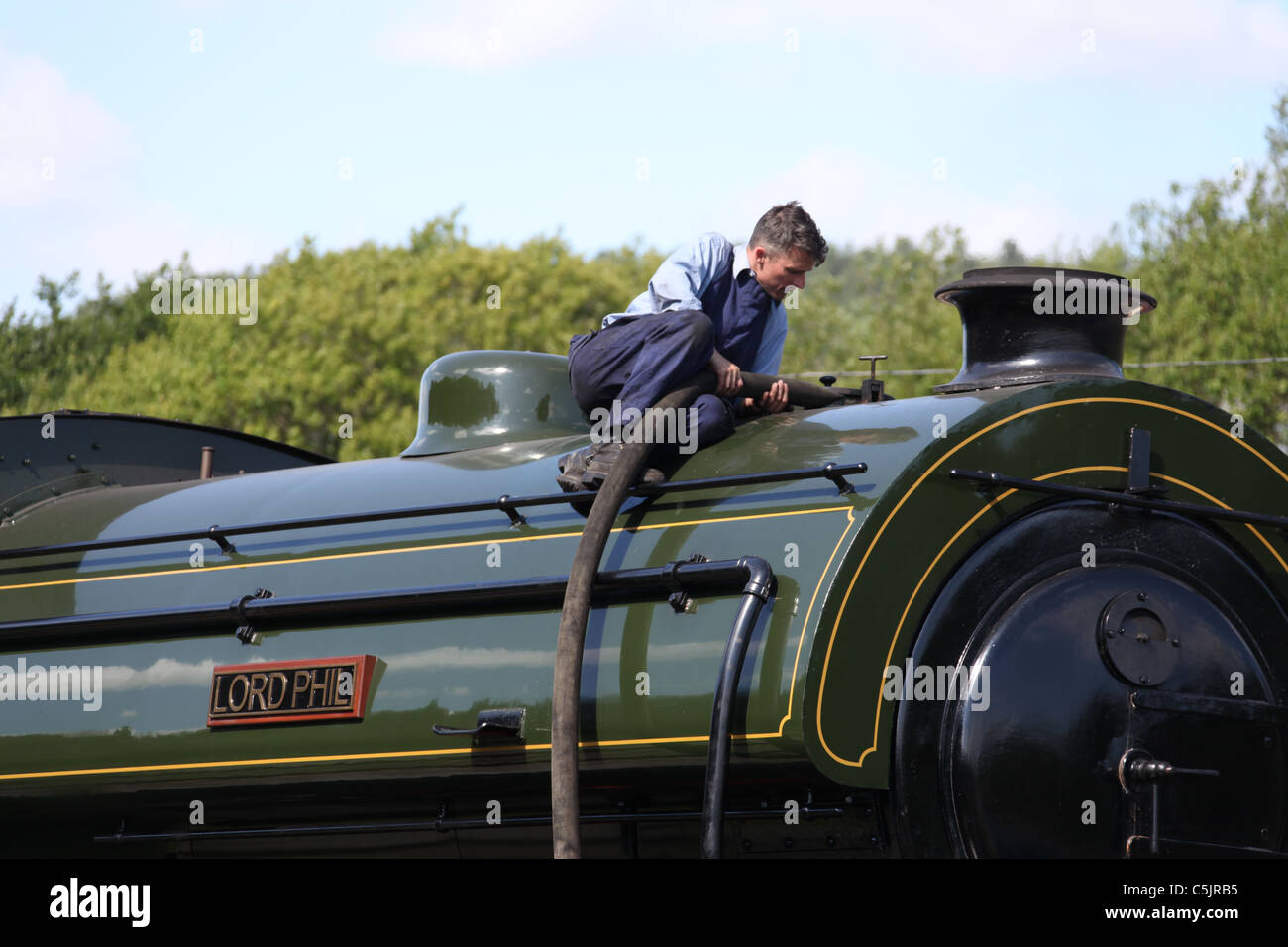 Filling up the water tank on a steam engine at Peak Rail Stock Photo ...