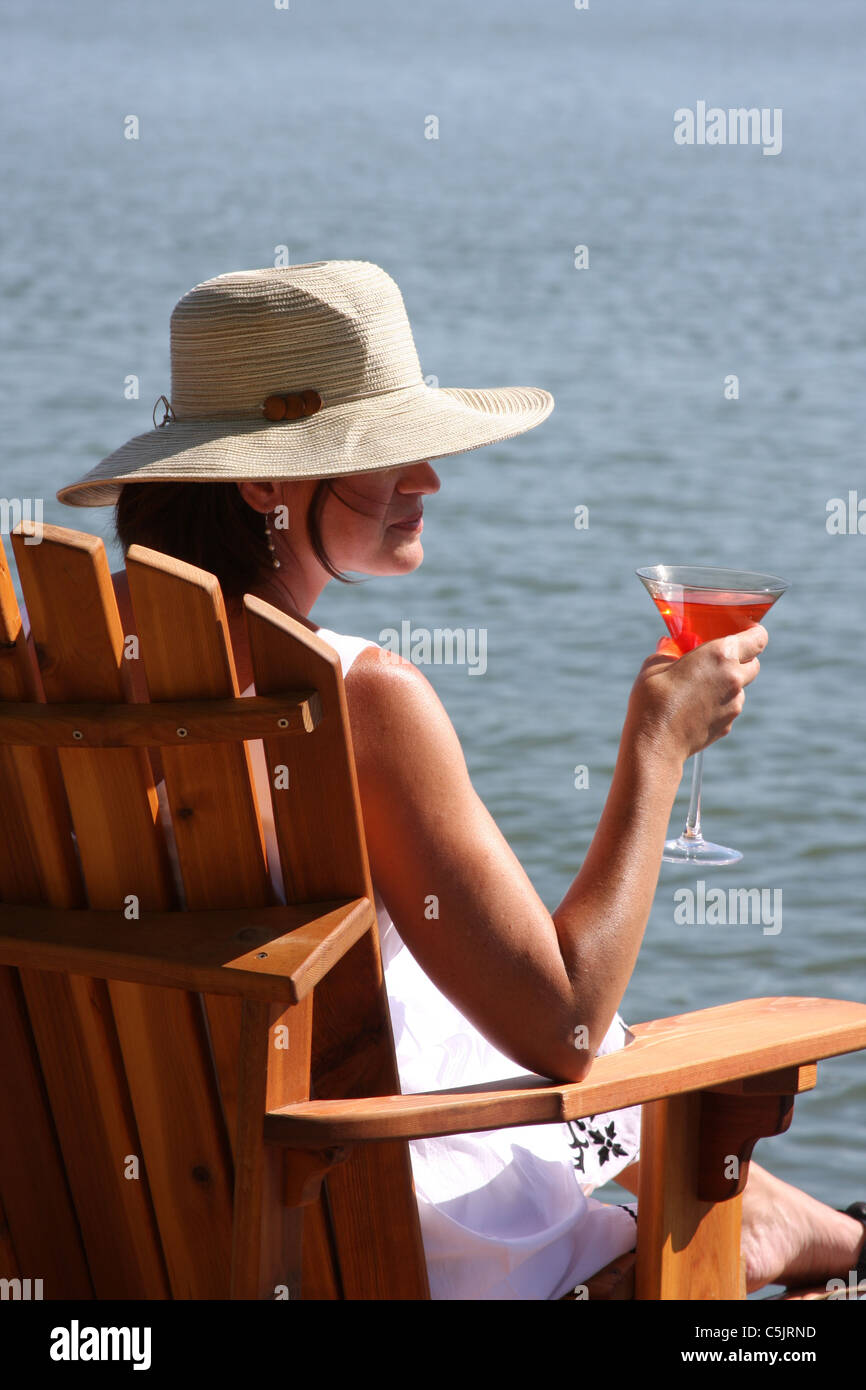 A lady drinking a cocktail next to a lake Stock Photo - Alamy