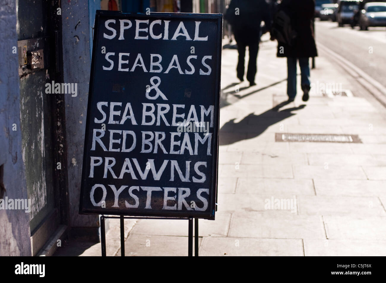 Fishmonger's sign on the pavement in London, England, selling seabass ...