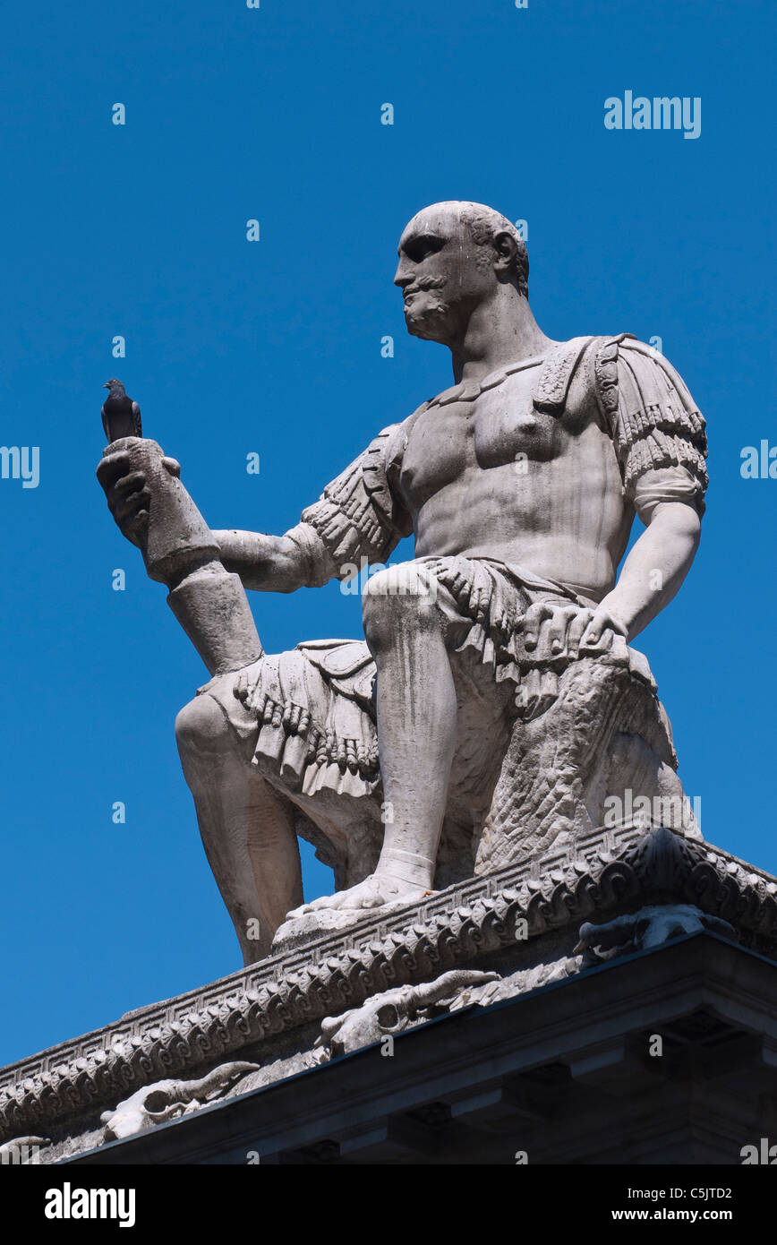 Classic public statue of a male figure in Florence, Italy with a pigeon ...