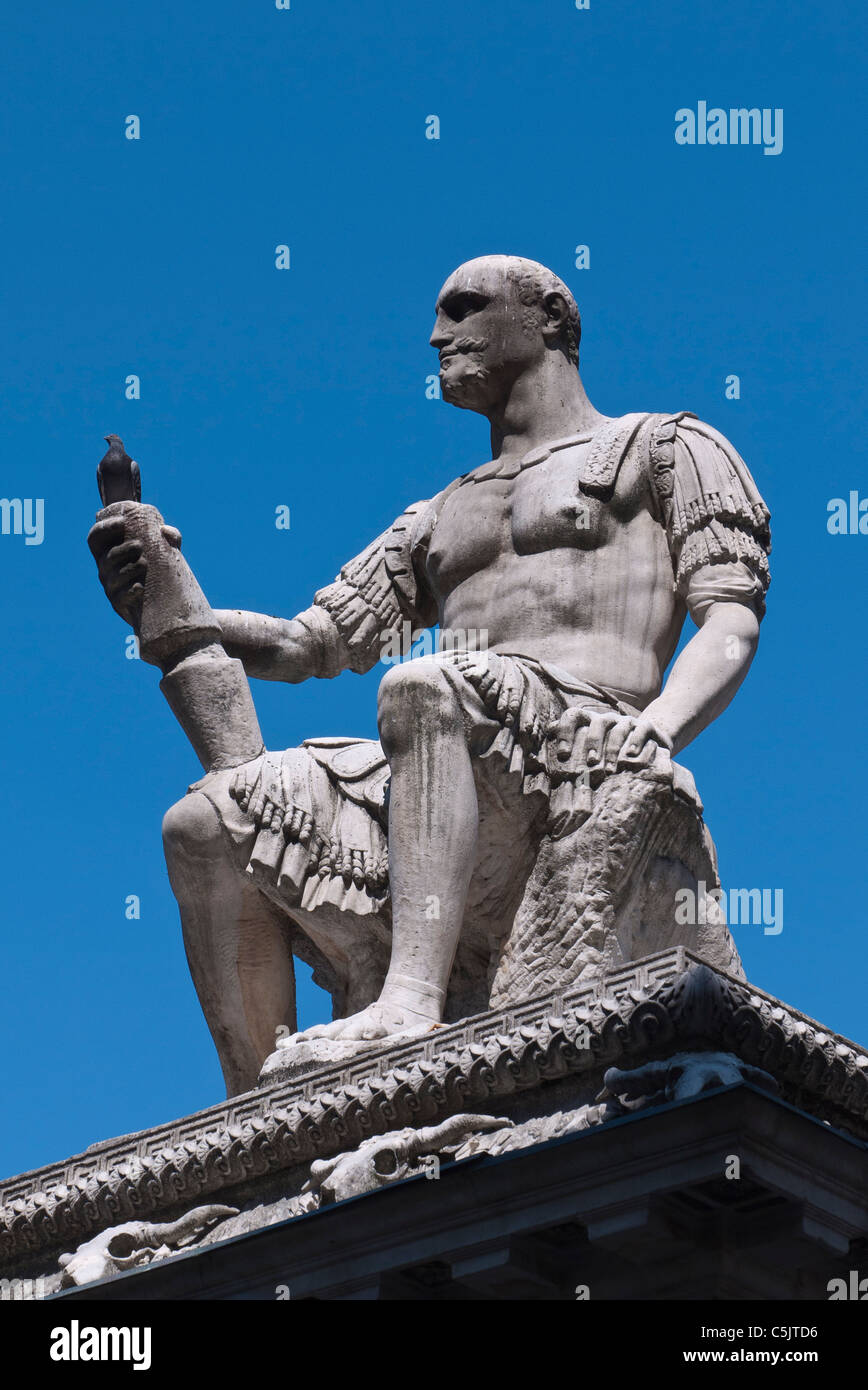 Classic public statue of a male figure in Florence, Italy with a pigeon ...