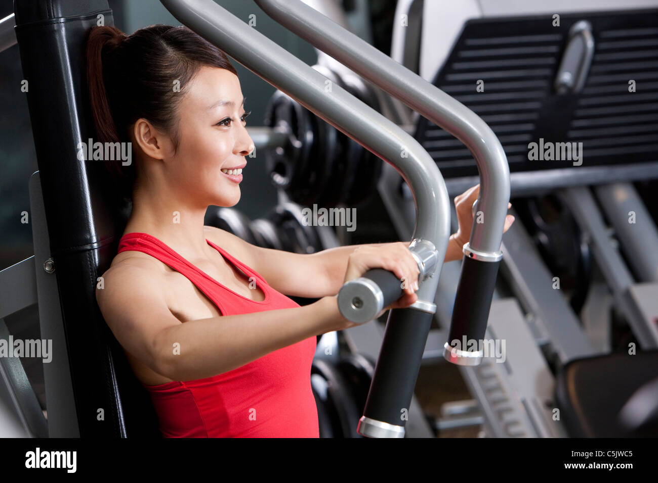 Young Woman Using Exercise Machine Stock Photo - Alamy