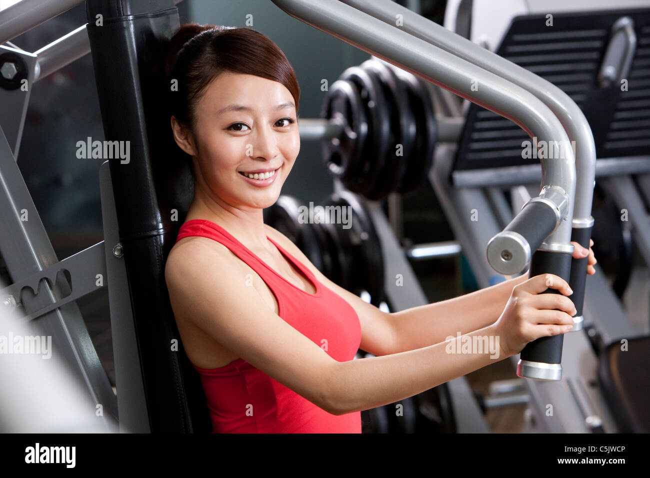 Young Woman Using Exercise Machine Stock Photo - Alamy