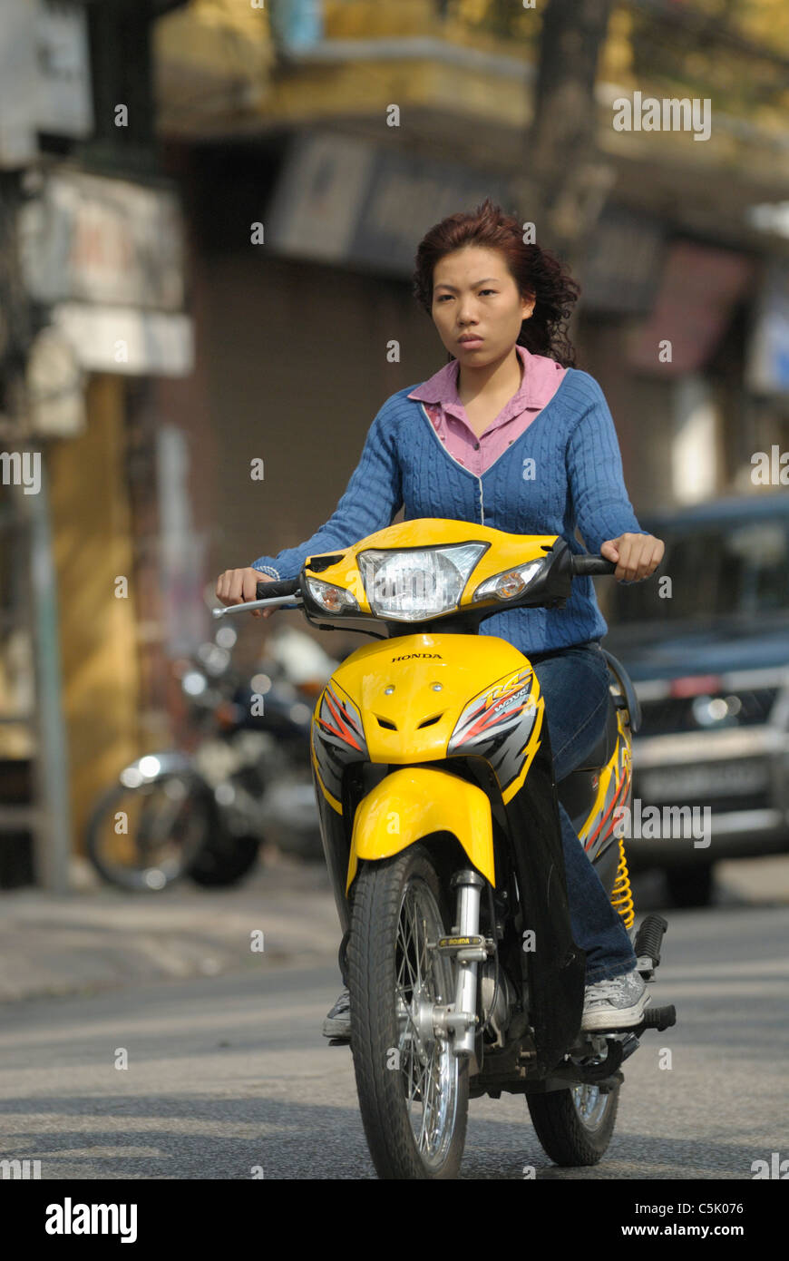 Asia, Vietnam, Hanoi. Hanoi old quarter. Young vietnamese woman rushing ...