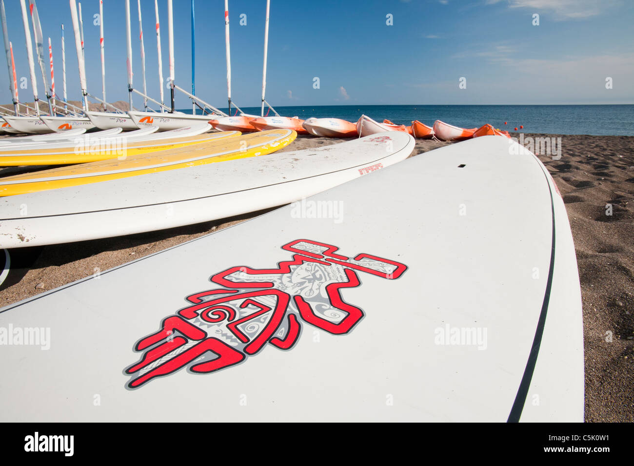 Sailing boats, kayaks, and stand up boards on the beach at an activity ...