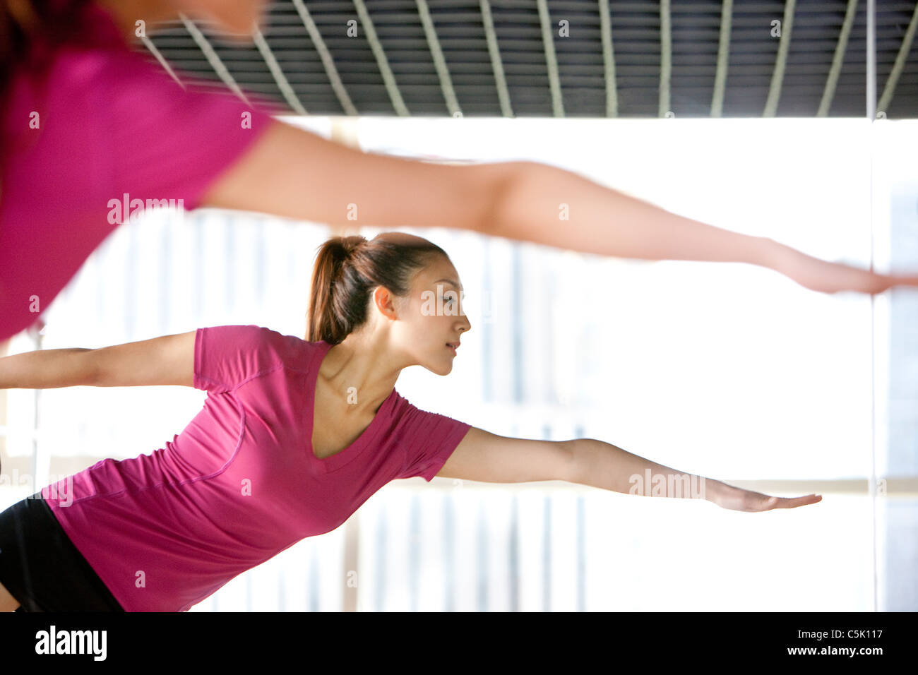 Young Woman Stretching in Front of Mirror Stock Photo - Alamy