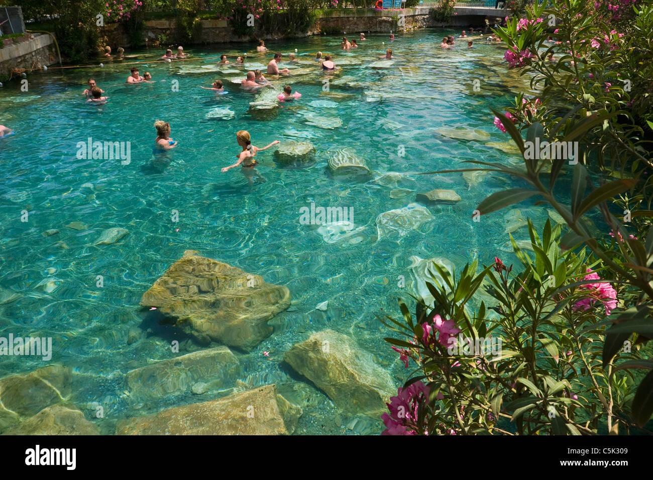 Tourists bathing and swimming in the ancient Sacred Pool of Hierapolis ...