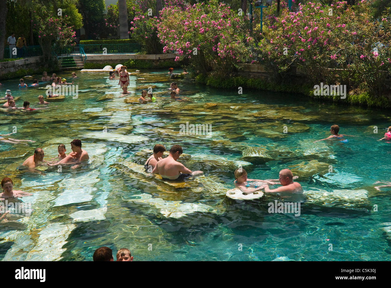 Tourists bathing and swimming in the ancient Sacred Pool of Hierapolis ...
