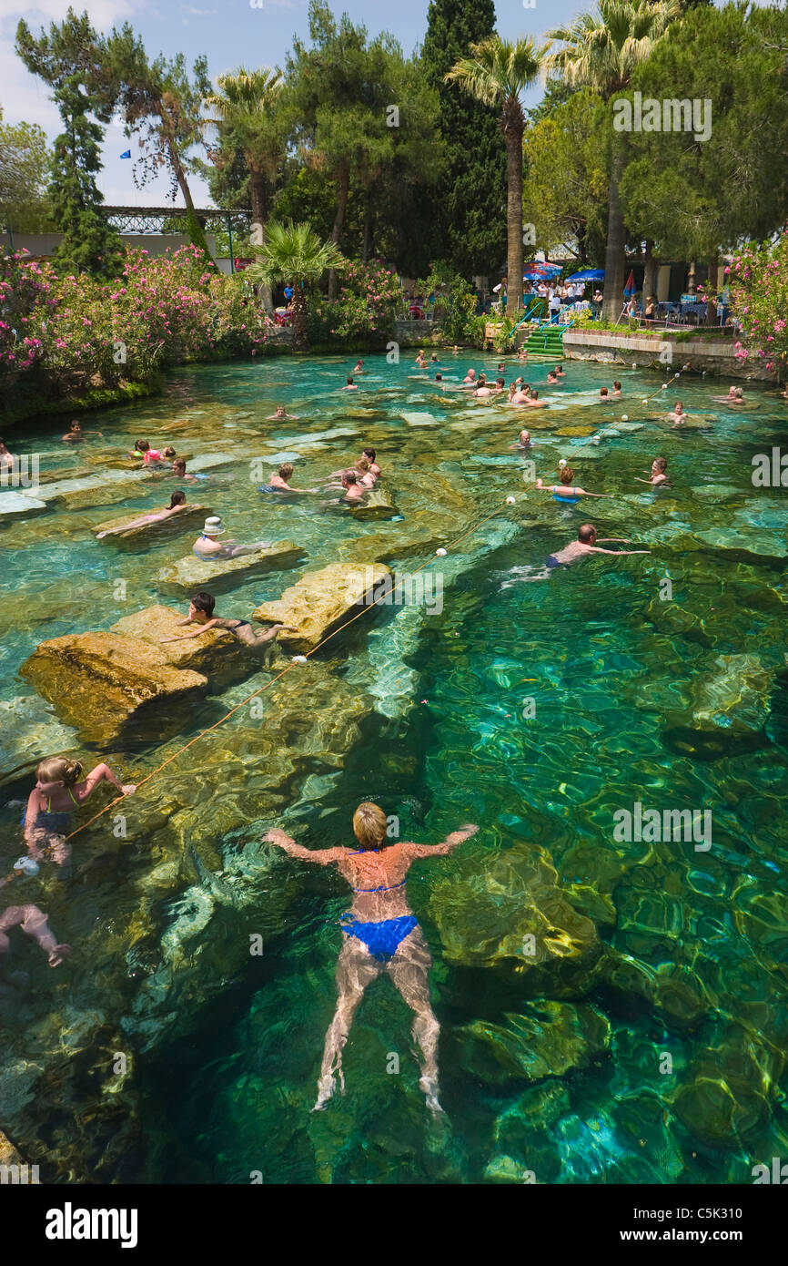 Tourists bathing and swimming in the ancient Sacred Pool of Hierapolis ...