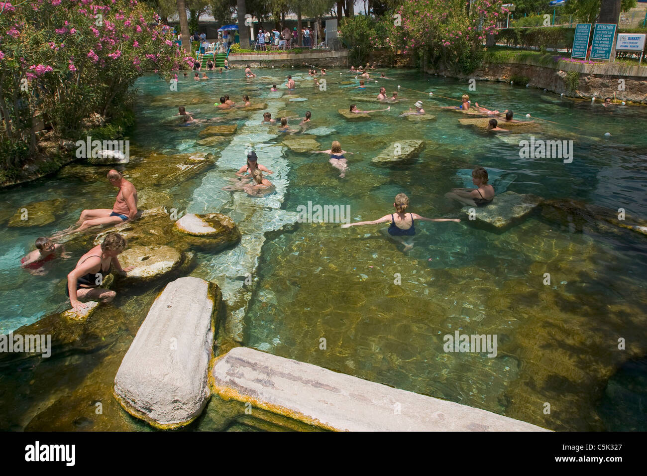 Tourists bathing and swimming in the ancient Sacred Pool of Hierapolis ...