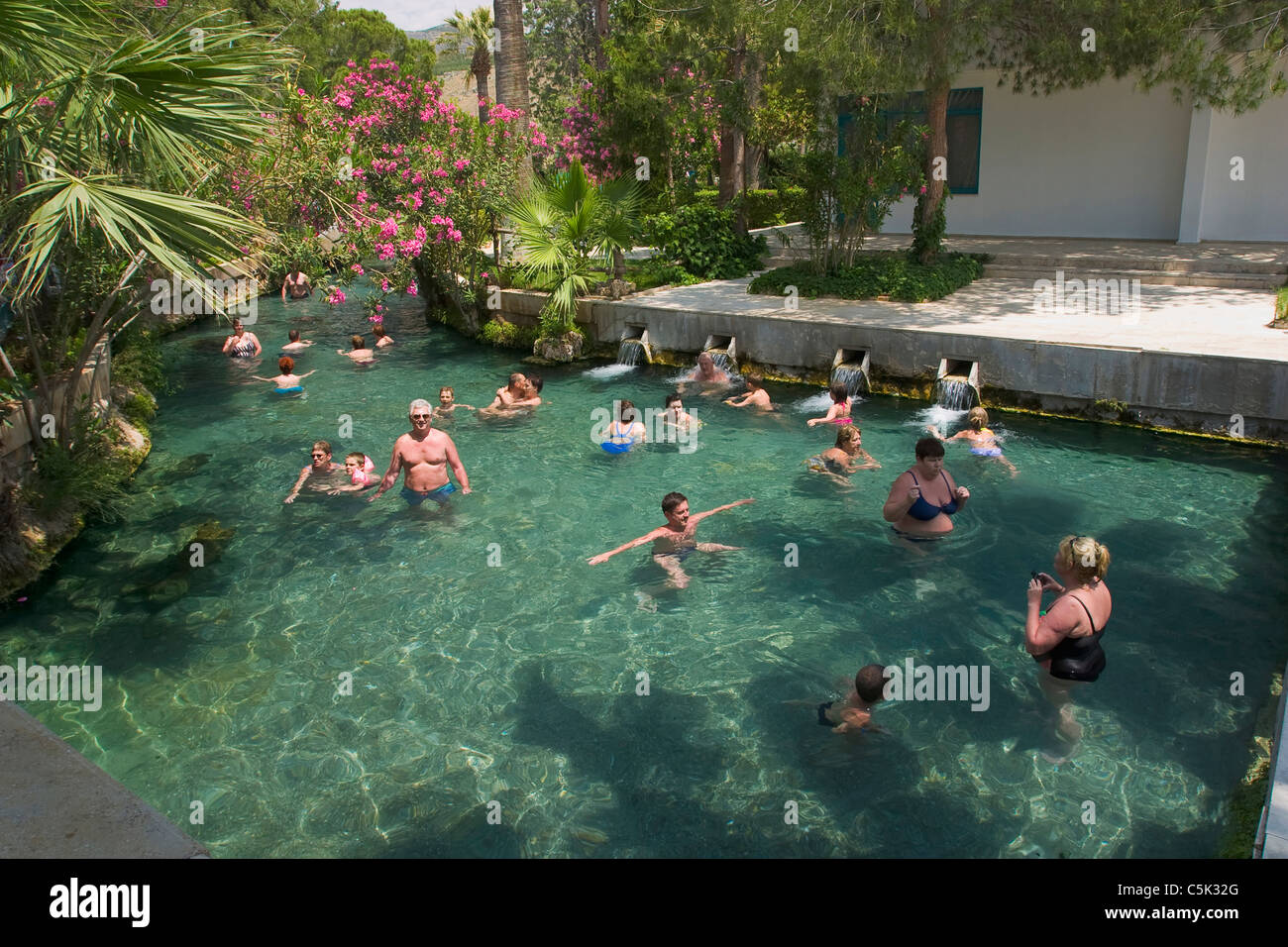 Tourists bathing and swimming in the ancient Sacred Pool of Hierapolis ...