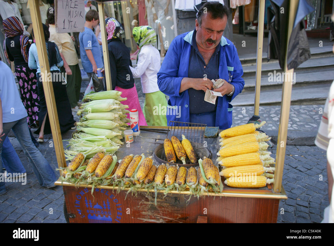 Roasted corn on the cob, and vendor counting the proceeds of the day ...