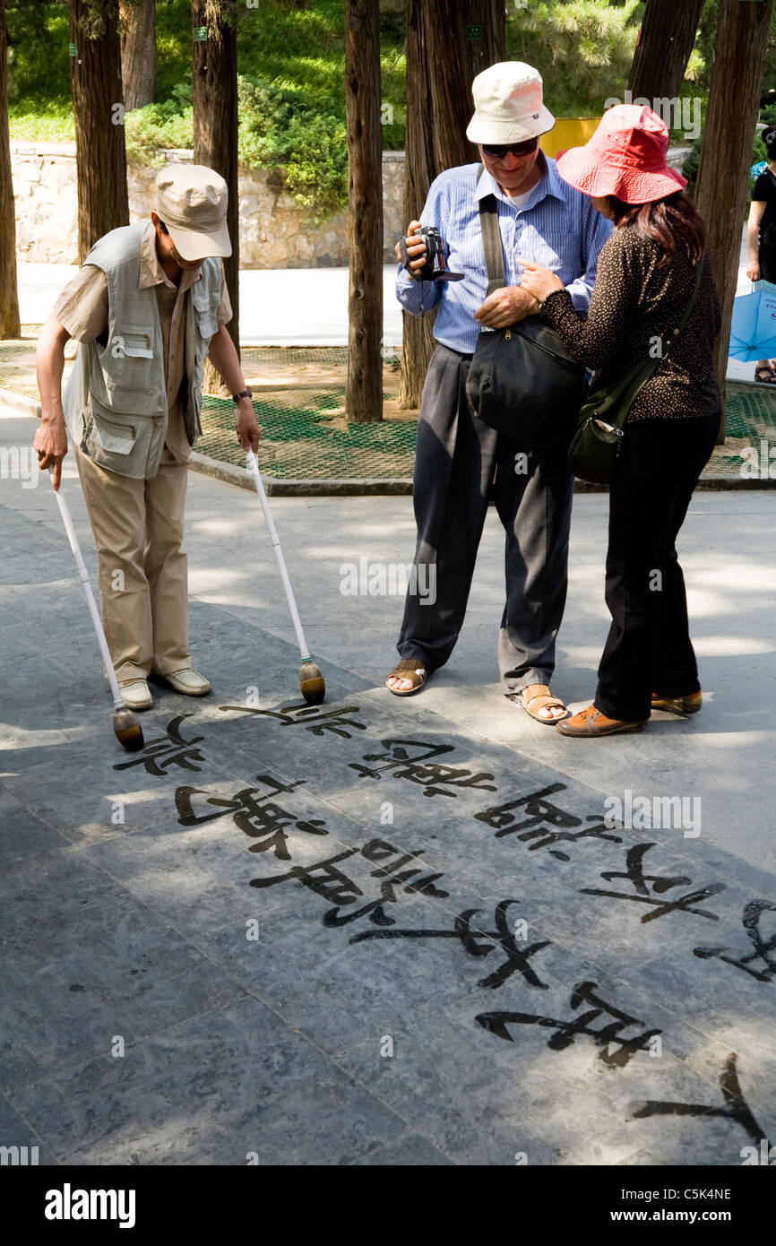 Busker exhibiting the art of calligraphy with water writing of Chinese ...